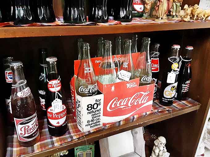 Vintage soda bottles lined up like soldiers remind us when beverages came in glass, cost pocket change, and tasted like actual ingredients instead of laboratory experiments.