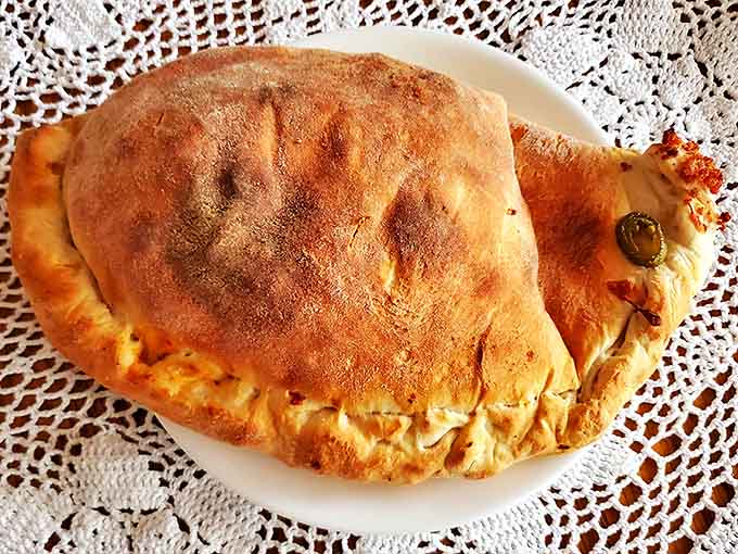 This calzone isn't just dinner &ndash; it's an event. Golden-brown exterior giving way to molten cheese, sausage, and the kick of jalape&ntilde;os.