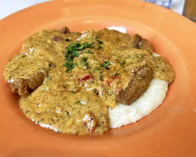 Catfish and grits &ndash; a Southern classic executed with finesse, where crispy cornmeal-crusted fish meets creamy grits in perfect harmony.