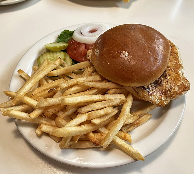 Golden-grilled chicken on a soft bun with crispy fries &ndash; simple food executed with the confidence of experience.