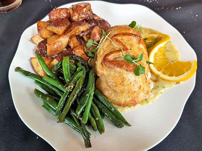 Chicken Wellington presents tender poultry wrapped in golden pastry alongside vibrant vegetables &ndash; comfort food elevated to art form.