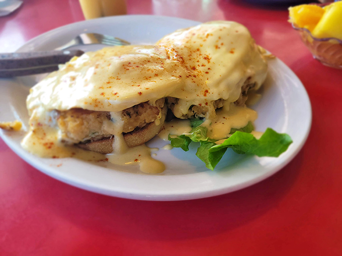 Breakfast reimagined: Crab cake benedict where perfectly poached eggs cascade hollandaise down seafood mountains, creating morning magic worth waking up for.