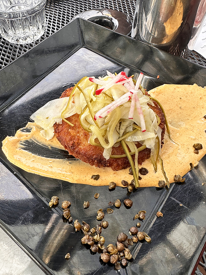 Crab Cake Golden-crusted treasure from the sea &ndash; this crab cake perches on a sauce canvas, adorned with pickled vegetable confetti.