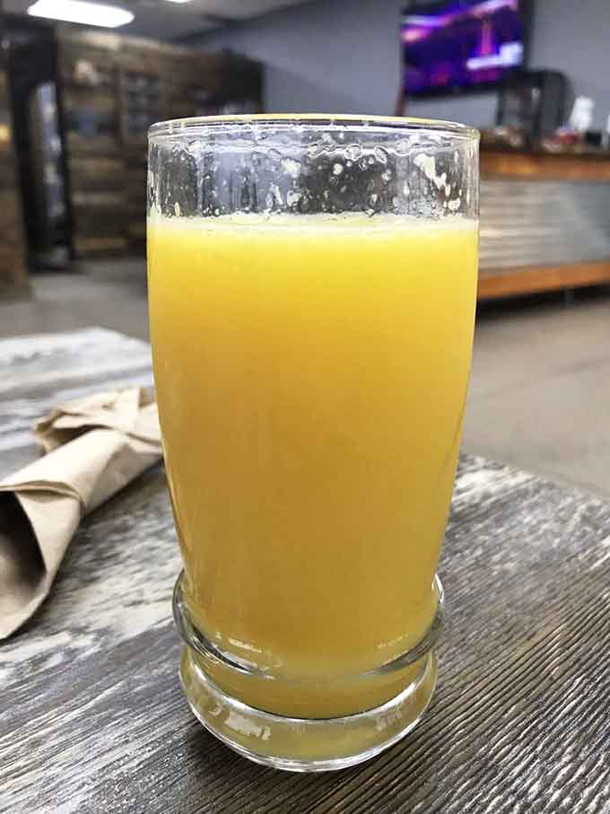 Fresh orange juice in a tall glass, the liquid sunshine your morning desperately needs to get started right.