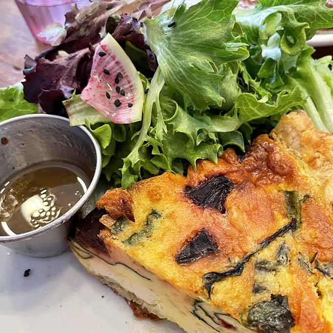 Quiche that respects the classics while adding fresh seasonal touches, served with greens that actually taste like something.
