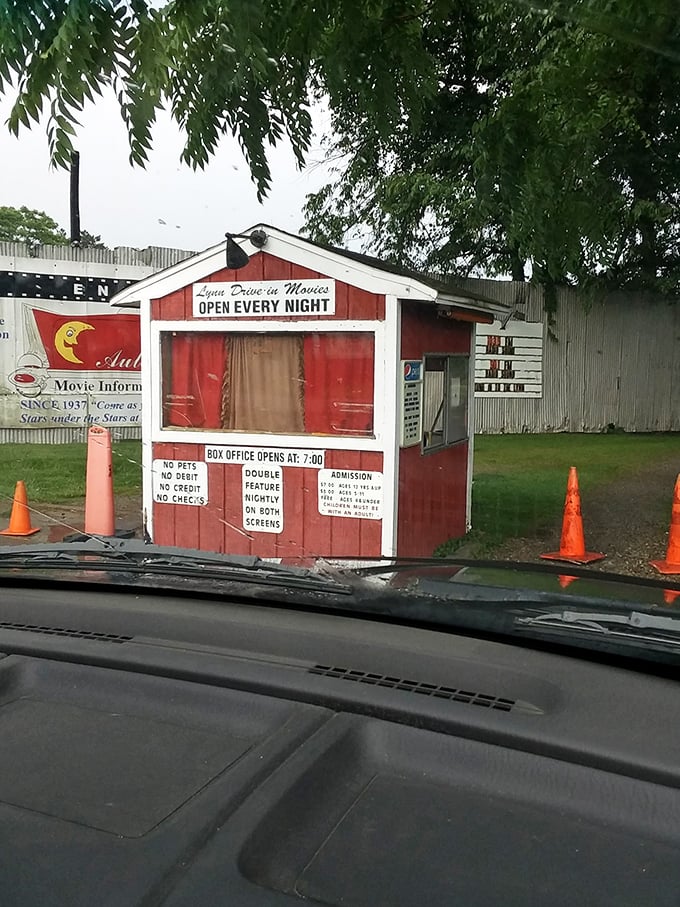 The humble ticket booth stands sentinel at the entrance, a red wooden time machine transporting visitors to simpler days.