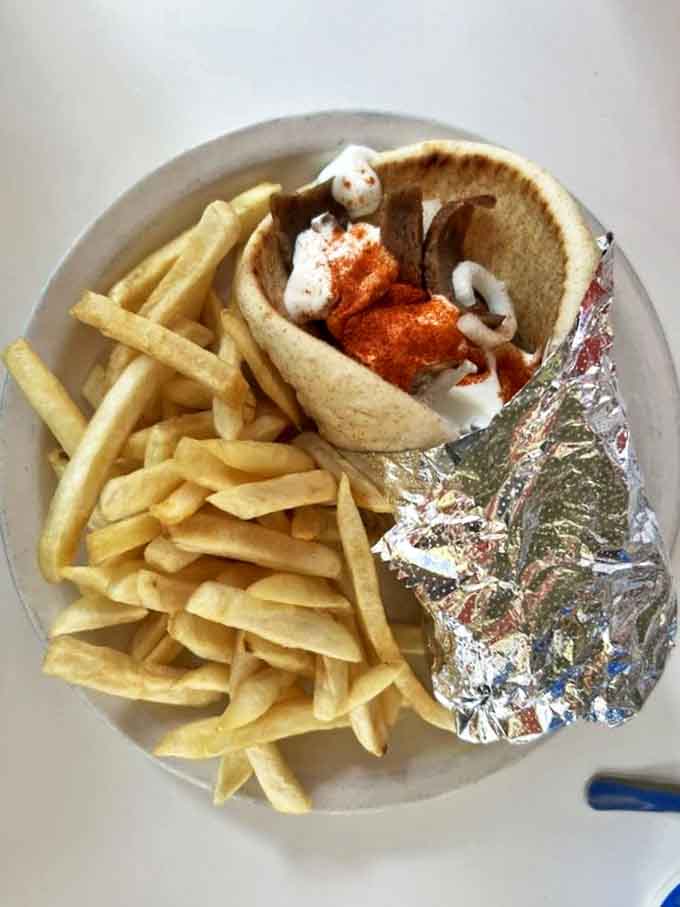 Beyond the Coneys, their authentic Greek offerings like this perfectly wrapped gyro sandwich prove this Detroit institution knows Mediterranean flavors too.