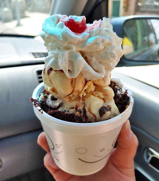 Hot fudge cascades over vanilla ice cream like a chocolate waterfall you'd happily swim in.