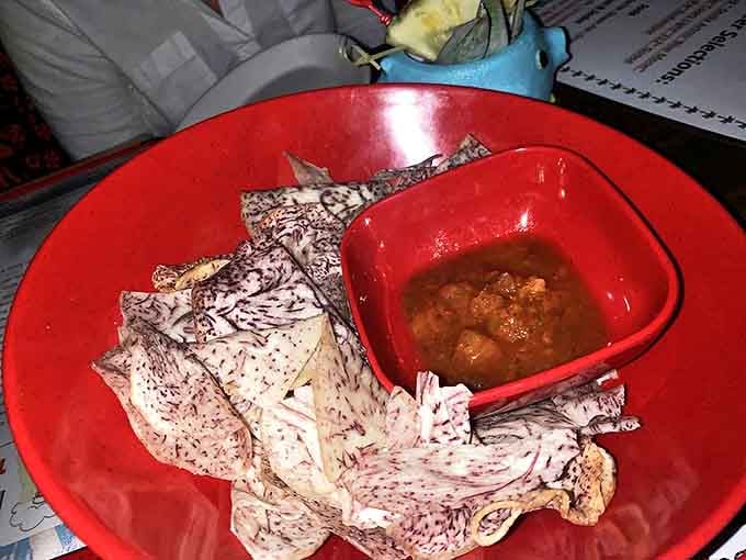 Taro chips with salsa offer a Hawaiian twist on a classic appetizer. The purple-flecked chips provide the perfect vehicle for the chunky, flavorful dipping sauce.