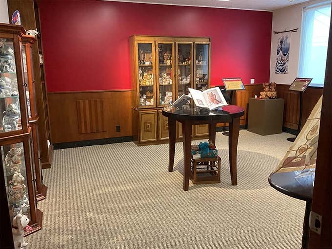 Rich wood cabinets house delicate collectibles in this elegant room where cat memorabilia gets the museum treatment it deserves.