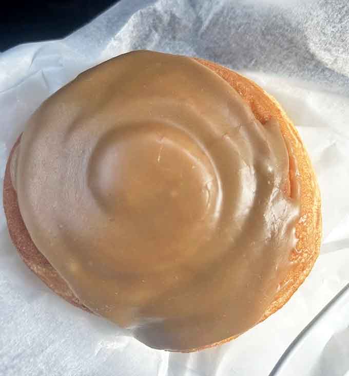 This isn't just a cinnamon roll – it's what happens when a cinnamon roll goes to finishing school and comes back with a fancy maple degree.