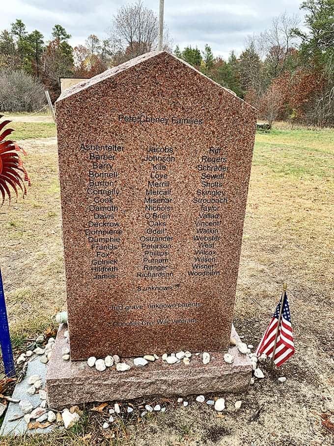 A modern memorial stone catalogs the family names of Pere Cheney's residents, ensuring they won't be forgotten as their individual markers fade away.