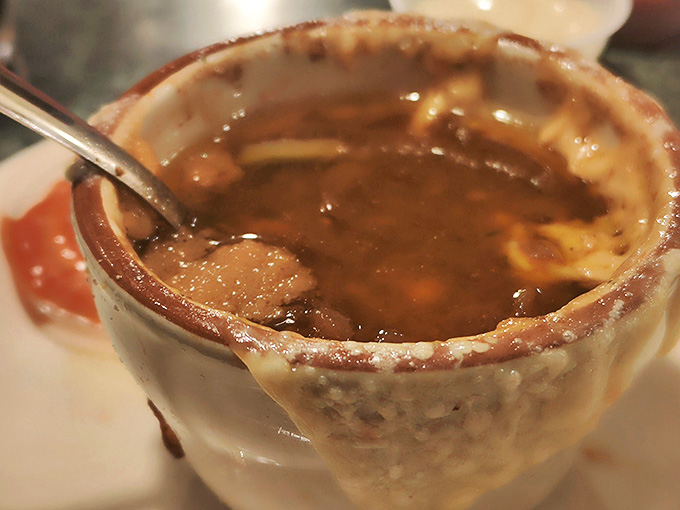 Steam rises from this crock of liquid comfort, where caramelized onions swim beneath a cap of broiled, stretchy cheese.