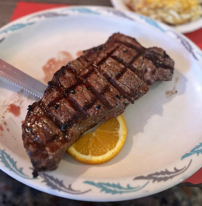 The New York Strip steak sits proudly on the plate, a testament to the art of perfect grilling and quality beef selection.