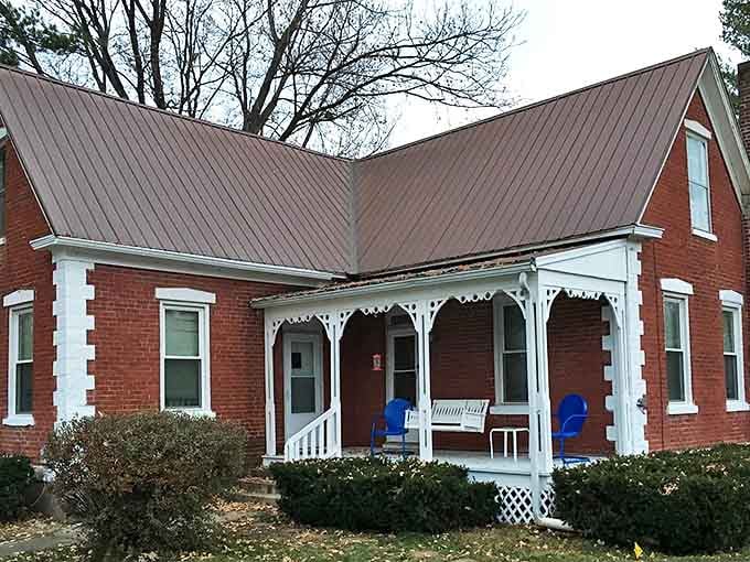 The cottage's side view reveals thoughtful landscaping and a pergola that frames the window like a living picture frame.