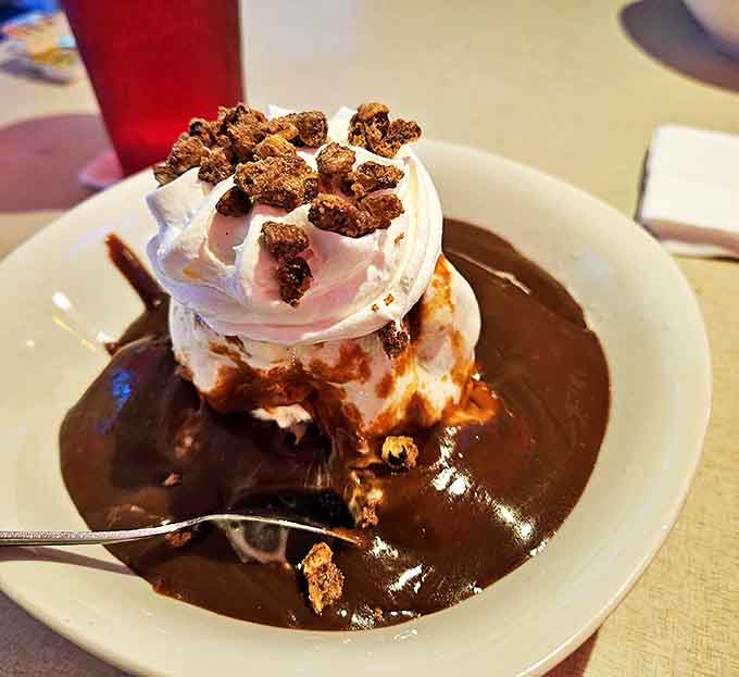 Hot fudge cascades over vanilla ice cream in this classic sundae that makes you wonder why anyone bothers with trendy desserts.
