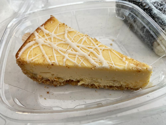 A slice of cheesecake that captures sunshine in dessert form, with a drizzle of white chocolate adding the perfect sweet finish.