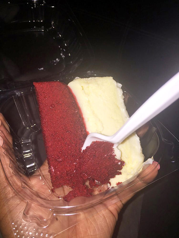 Half-eaten red velvet cheesecake reveals the perfect texture &ndash; dense yet light, with that distinctive crimson layer playing beautifully against classic cheesecake creaminess.