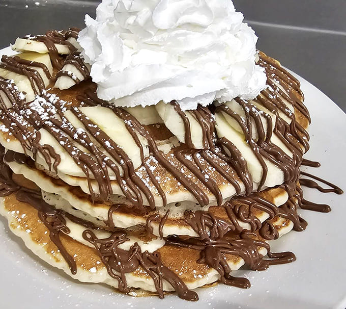 Banana Nutella Pancakes stacked high and drizzled with chocolate, proving that sometimes breakfast should absolutely be dessert and nobody should feel guilty about it.