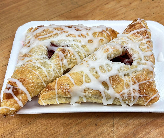 These strawberry turnovers glisten with sweet glaze, their flaky exteriors barely containing the ruby filling that waits to escape with each delicious bite.