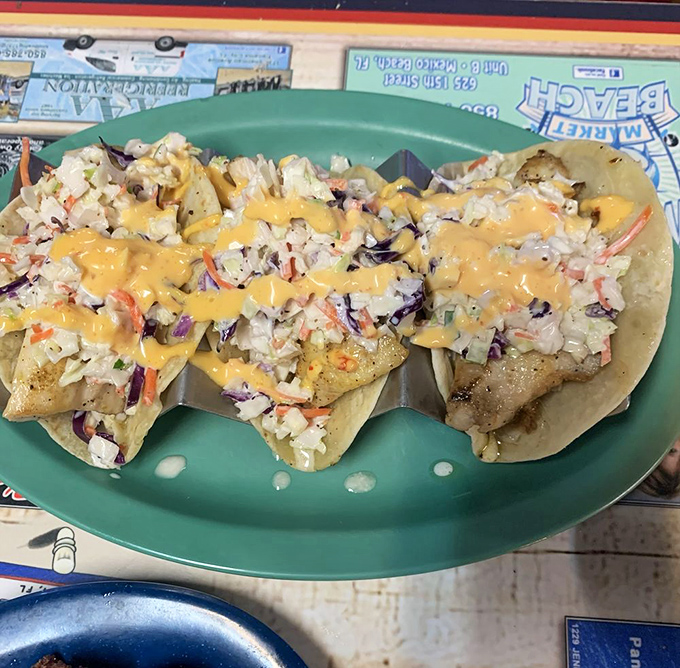 Fish tacos topped with fresh slaw and special sauce – proof that sometimes the simplest combinations create the most memorable flavors.