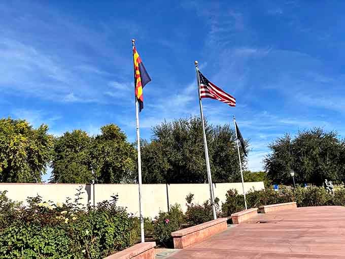 Three flags wave proudly above the roses, reminding visitors that this beautiful space belongs to everyone who calls this community home.