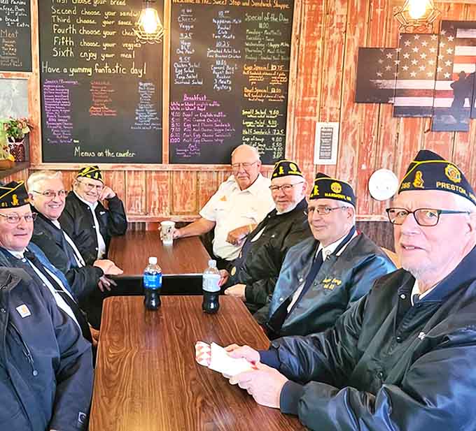 Local veterans gather around tables, proving that good food creates community as they share stories over coffee and legendary cheesecake.