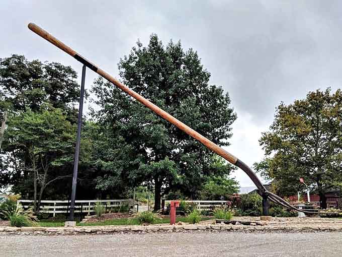 White picket fences and autumn trees provide a charming backdrop for this decidedly uncharming-sized farming implement.