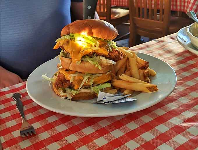 This towering burger construction demands a strategy before the first bite &ndash; worth every napkin you'll need during the delicious challenge.