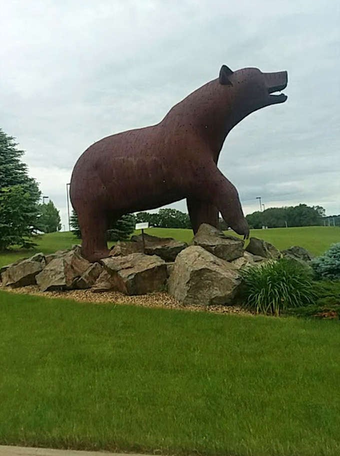 This imposing metal bear surveys its domain from atop a rocky perch, its rusty coat gleaming in the Midwestern sun.