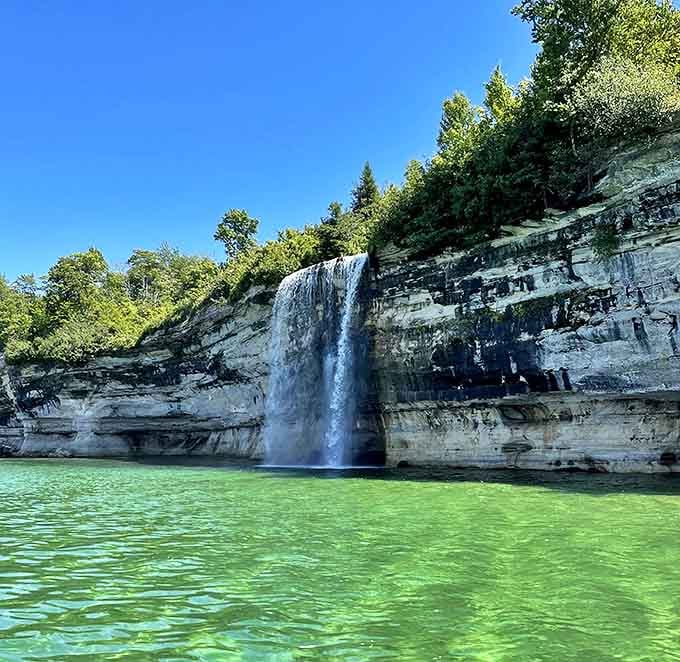 From this angle, you can truly appreciate how the waterfall seems to pour straight from the forest into the endless blue below.