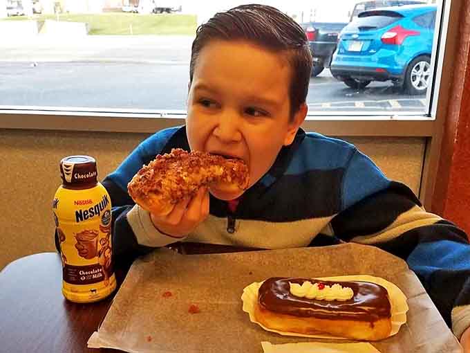 A young customer experiencing that universal childhood joy &ndash; the perfect combination of chocolate milk and fresh donuts.
