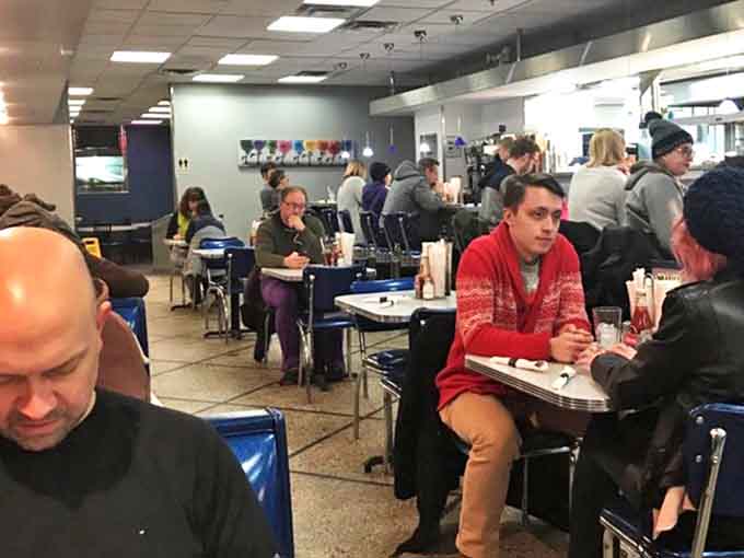 The dining room buzzes with energy as patrons from all walks of life unite under the universal language of "pass the syrup, please."