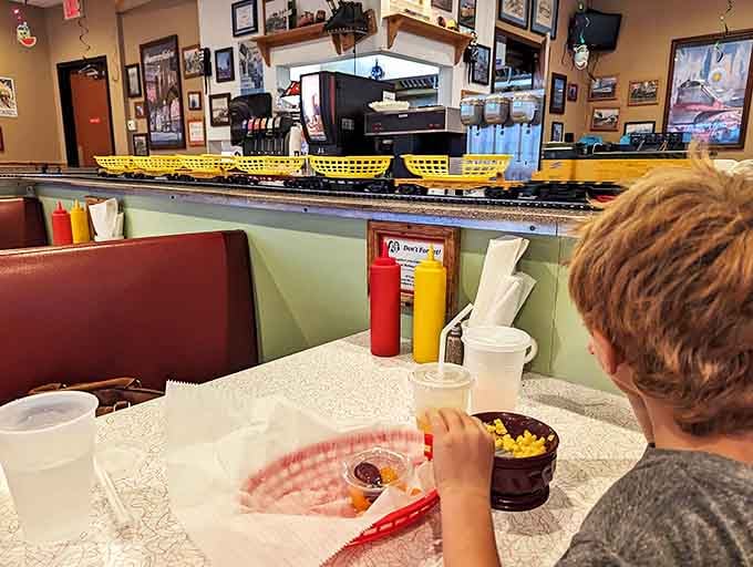 Red vinyl seats and overhead train tracks create the perfect setting for families to gather and watch their meals make the journey.
