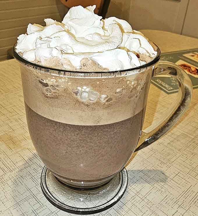 Hot chocolate that puts Swiss miss to shame, crowned with a cloud of whipped cream so generous it threatens to escape the mug.