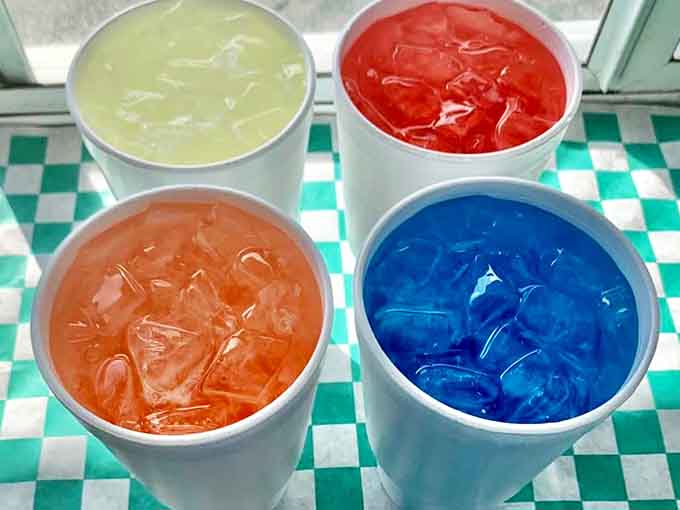 Four flavors of lemonade stand ready to quench your thirst, each one bright enough to make your eyes water with anticipation.