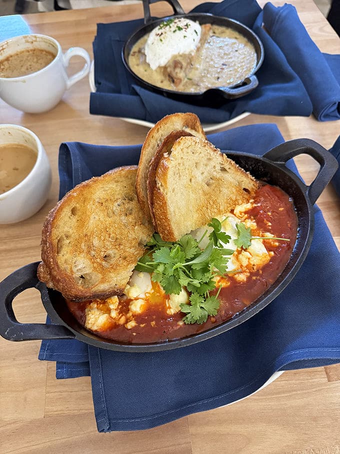 Shakshuka served in a cast-iron skillet with toasted bread proves breakfast here is serious business worth waking up for.