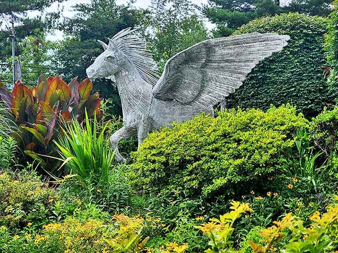 The majestic Pegasus statue stands frozen mid-flight, surrounded by lush gardens that enhance its mythological presence.