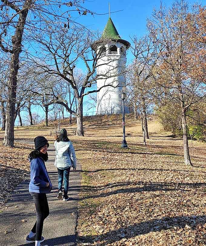 Young adventurers pose with a surprisingly realistic dinosaur statue, creating memories that will outlast even the Stone Age.