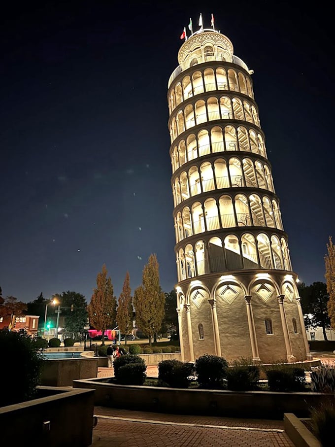 Golden illumination bathes the tower at night, highlighting each tier and arch in a warm glow that showcases its impressive architectural details.