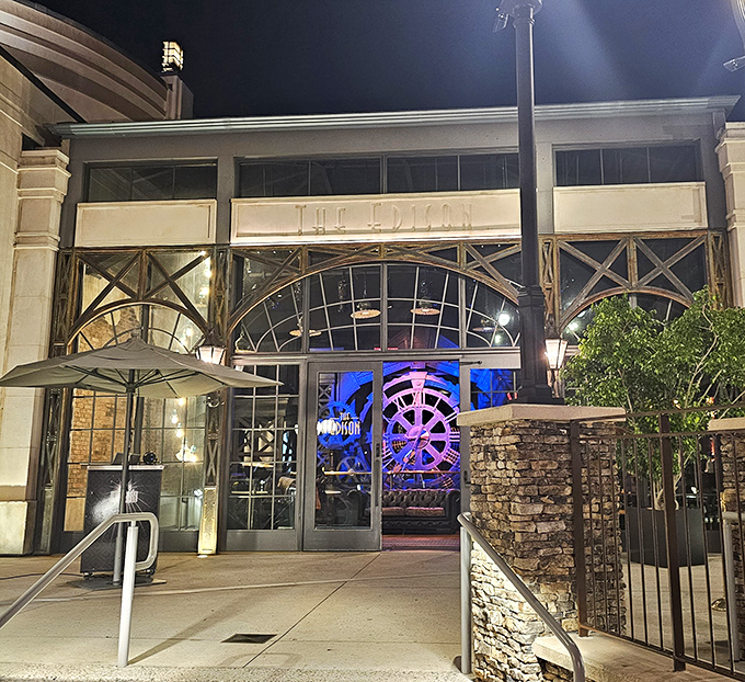 Evening transforms The Edison's facade with dramatic lighting highlighting its vintage industrial design. The illuminated interior promises a night of Gatsby-era glamour.