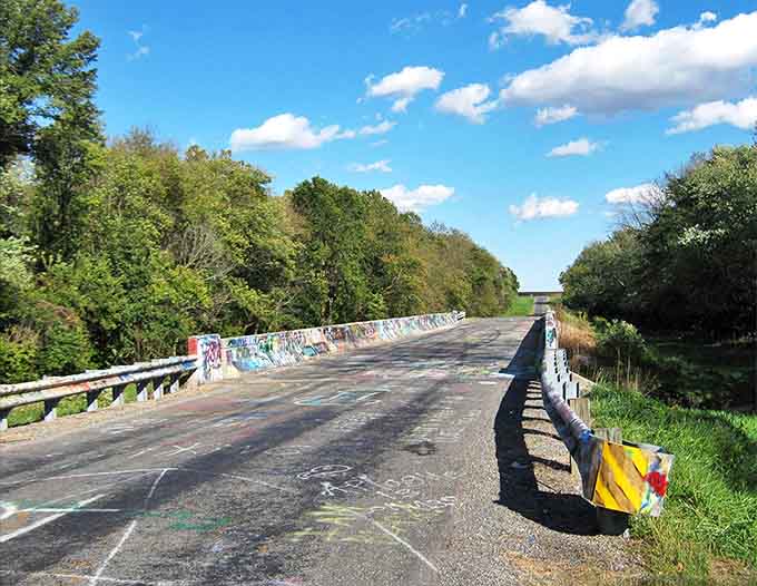 The infamous Acid Bridge stretches into the distance, its graffiti-covered rails like colorful sentinels guarding forgotten secrets.