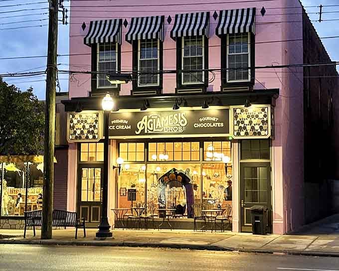 The iconic pink facade of Aglamesis Bros. glows invitingly at dusk, its black and white striped awnings beckoning sweet-toothed visitors inside.
