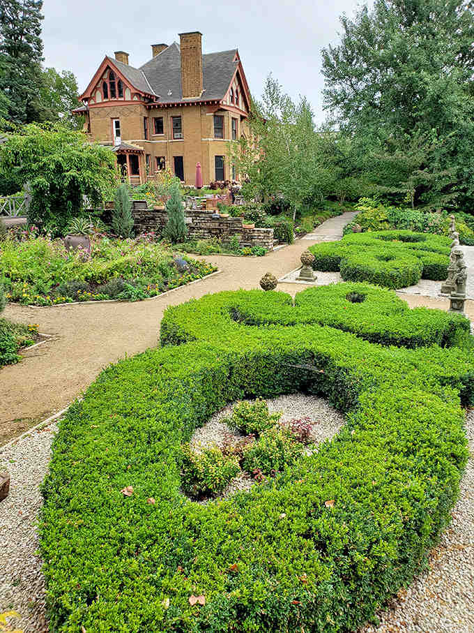 A Victorian Gothic masterpiece stands guard over meticulously designed gardens, like a storybook mansion come to life.