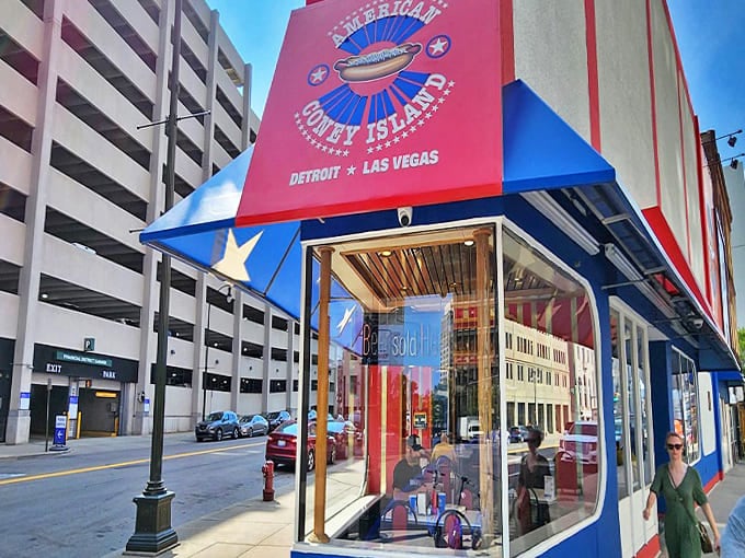 American Coney Island's vibrant red, white, and blue exterior stands as a patriotic beacon of comfort food in downtown Detroit, promising delicious memories since 1917.