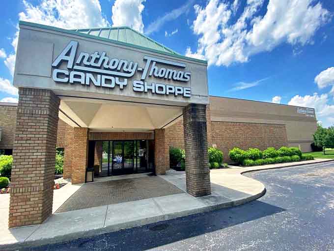 The inviting brick facade of Anthony-Thomas Candy Shoppe stands ready to welcome chocolate pilgrims with its distinctive green-topped entrance.