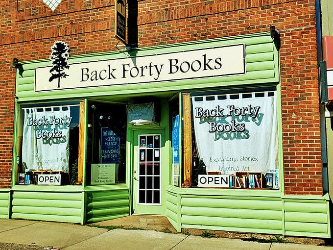 The inviting mint-green storefront of Back Forty Books beckons bibliophiles with its charming fa&ccedil;ade and iconic pine tree logo.