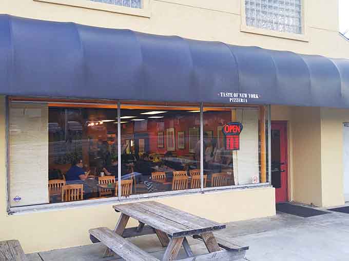 A modest yellow building with a blue awning promises little but delivers big &ndash; the unassuming facade of pizza paradise hiding in plain sight.