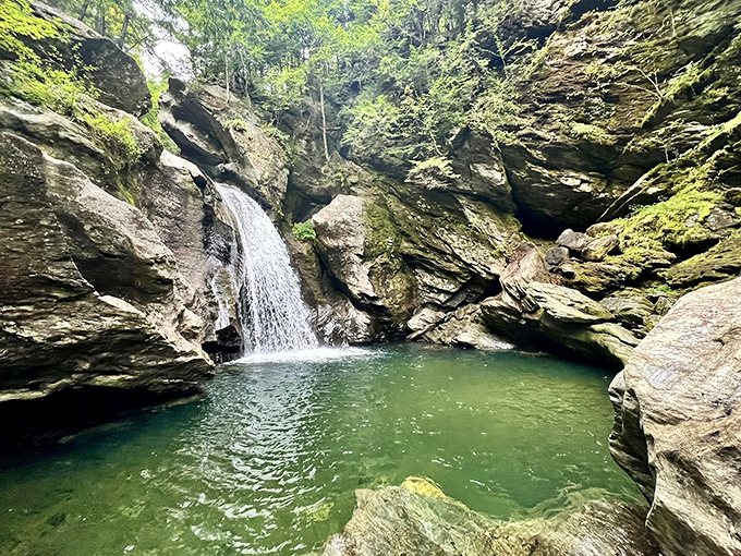 Nature's perfect plunge pool: Emerald waters invite brave souls while moss-kissed rocks frame this hidden Vermont gem.