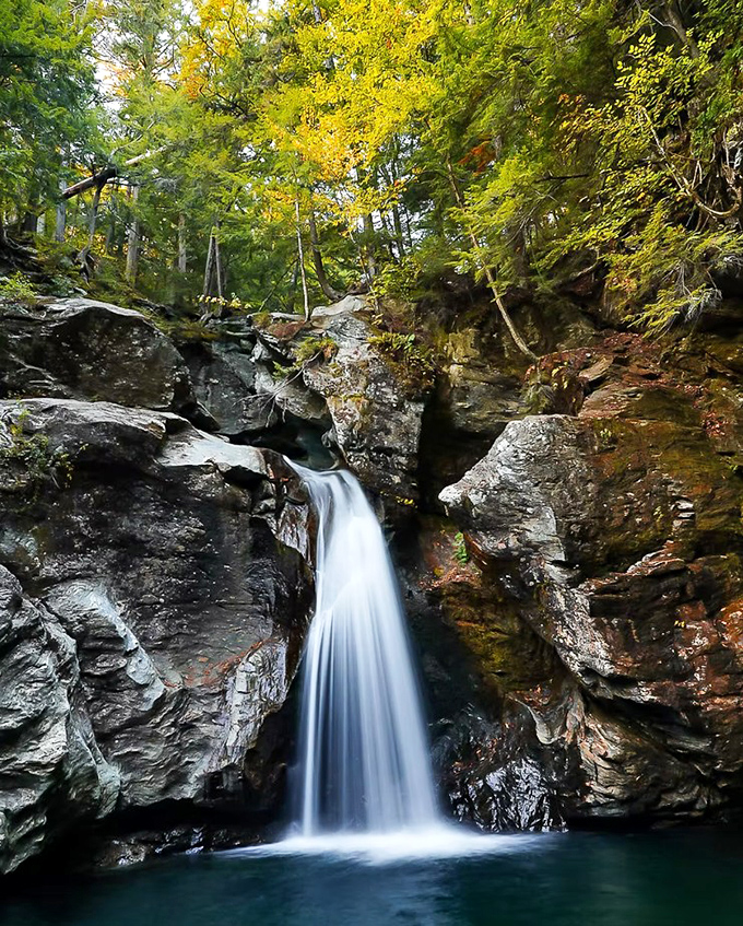 Nature's perfect cascade: Bingham Falls tumbles 25 feet into an emerald pool, framed by ancient rock walls sculpted over millennia.
